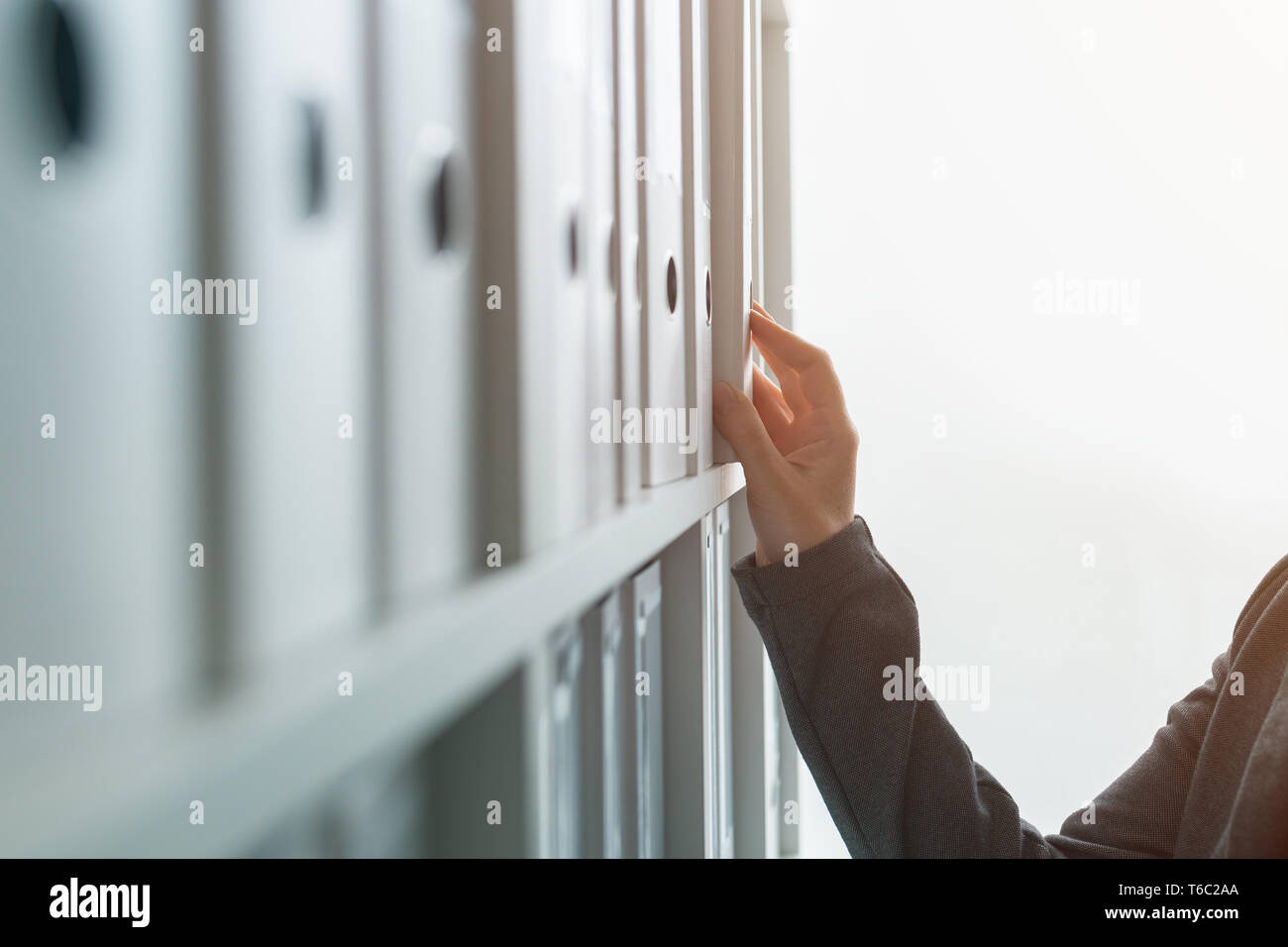 Businesswoman browsing through ring binder file documentation archives ...