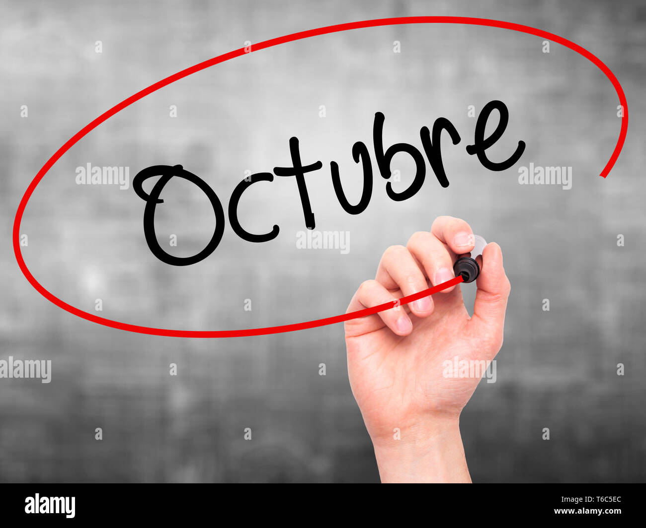 Man Hand writing quot;Octubrequot; (In Spanish: October) with black ...