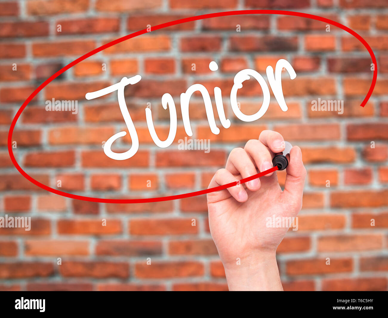 Man Hand writing Junior with black marker on visual screen Stock Photo ...