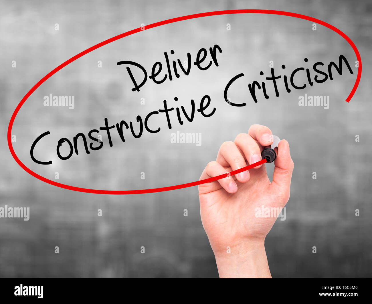 Man Hand writing Deliver Constructive Criticism with black marker on ...