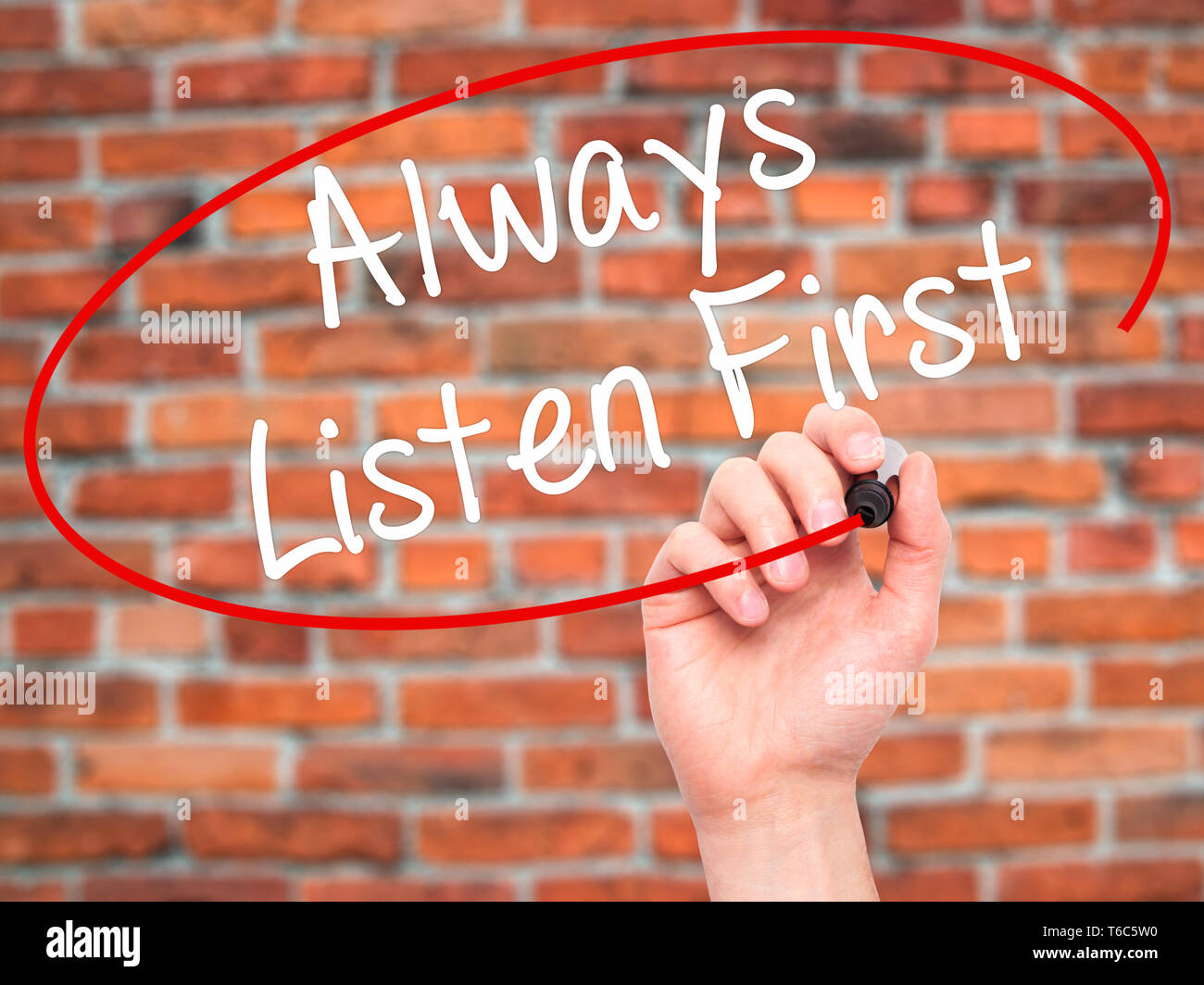 Man Hand writing Always Listen First with black marker on visual screen ...