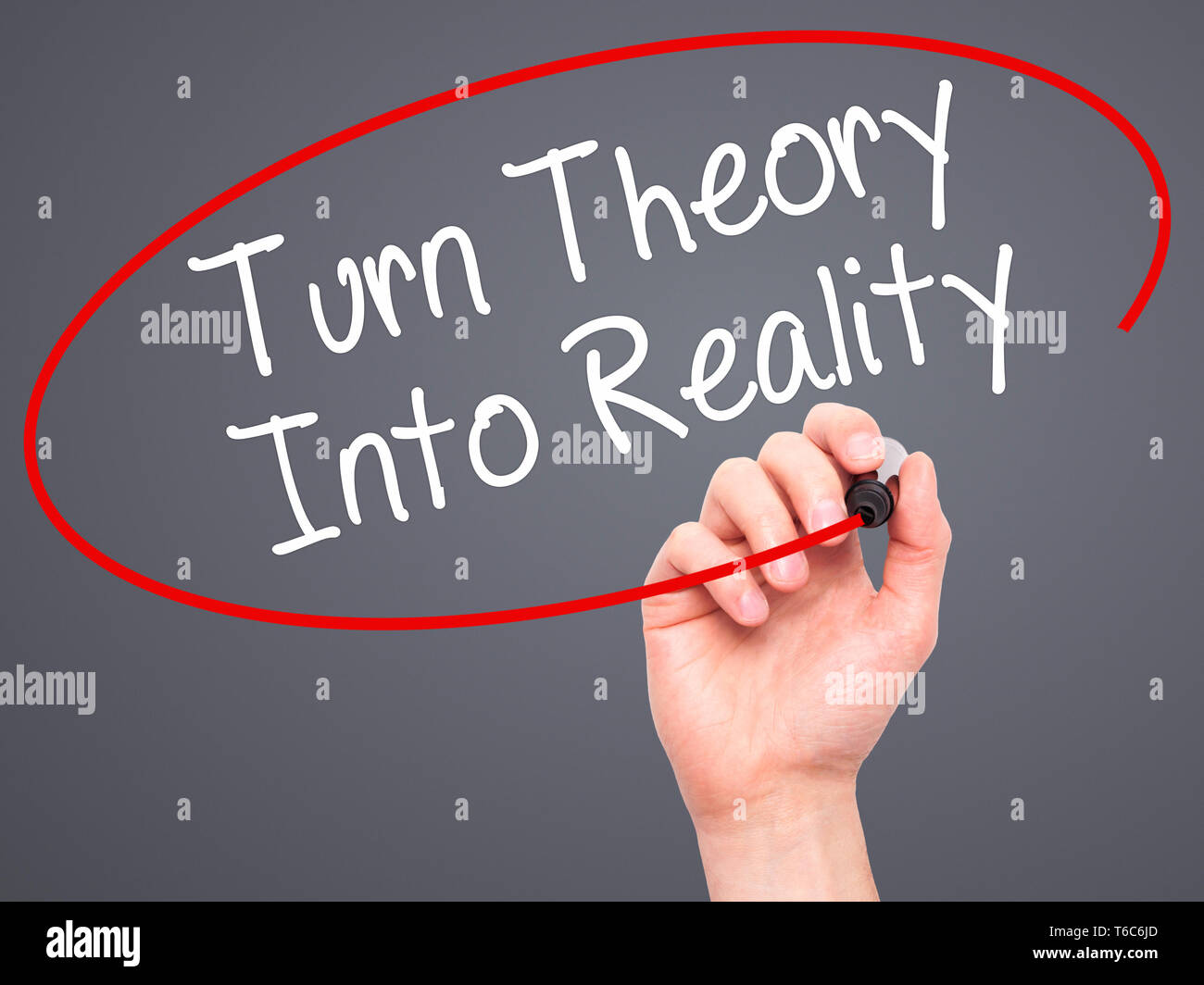 Man Hand writing Turn Theory Into Reality with black marker on visual ...