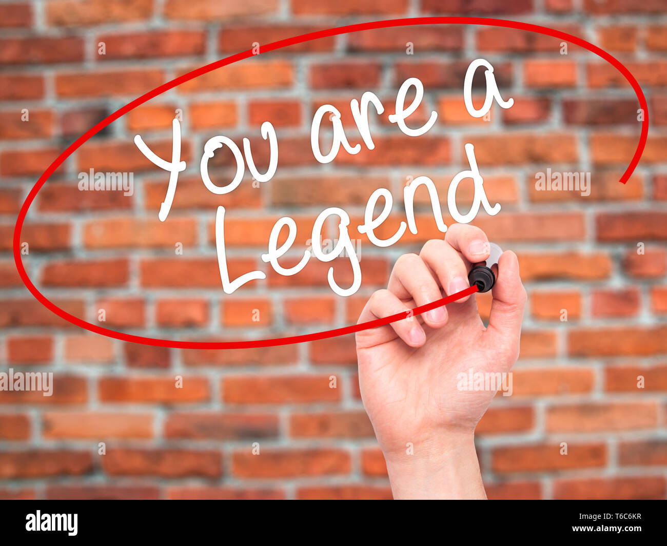 Man Hand writing You are a Legend with black marker on visual screen ...
