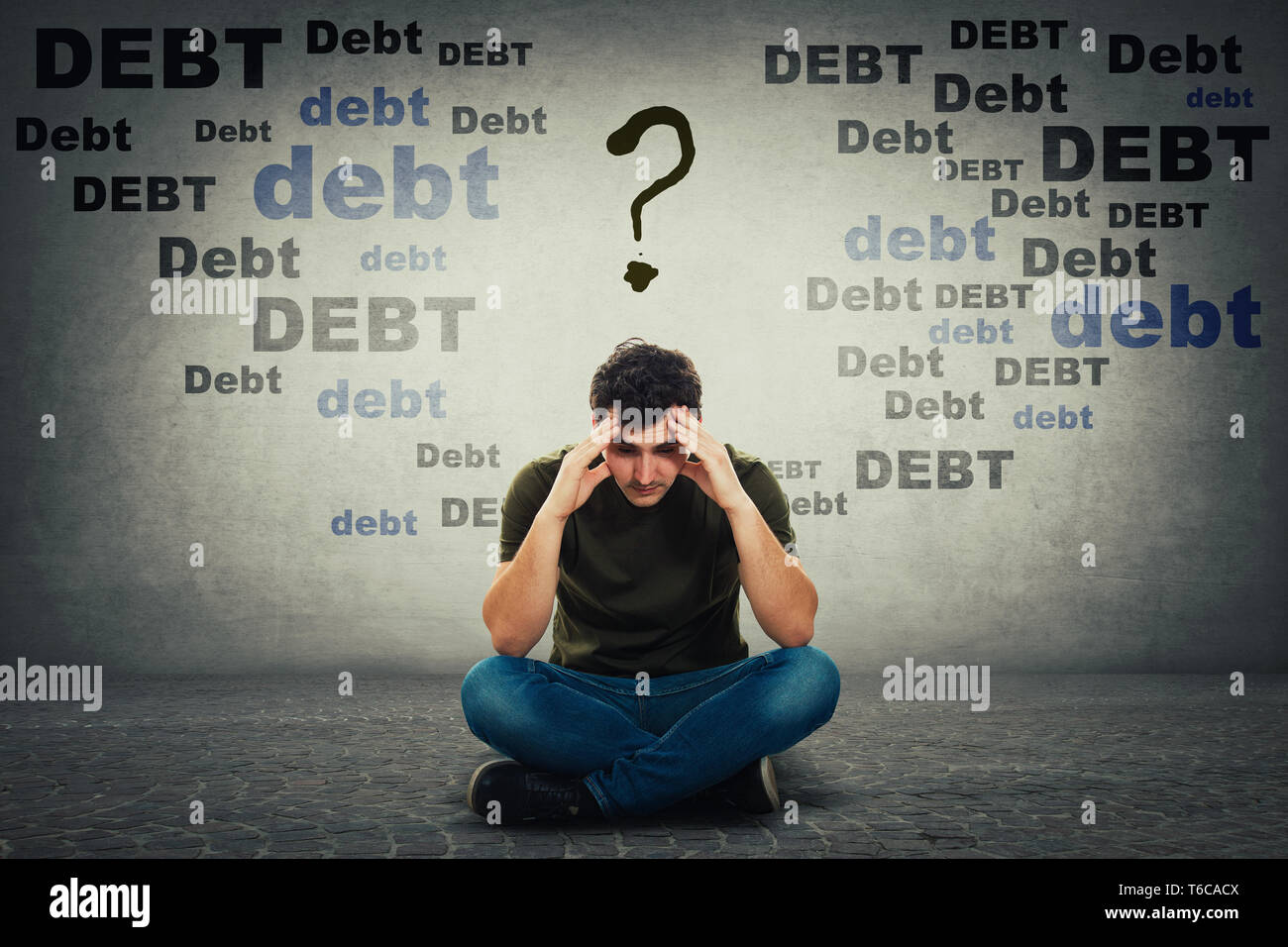 Emotional shock, upset and tired young man seated on the floor keeps ...