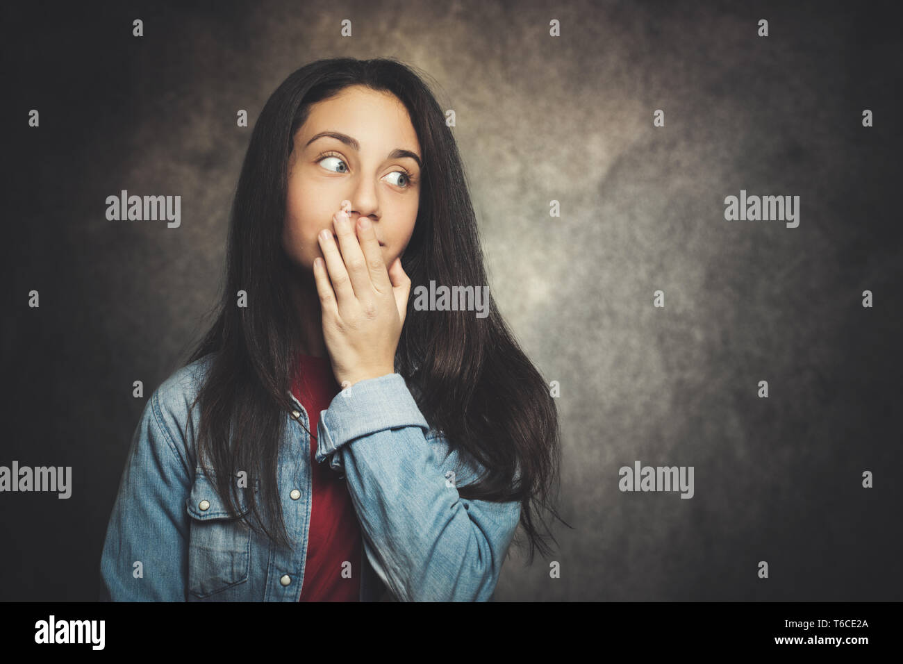 Embarrassed young girl on a grungy background Stock Photo - Alamy