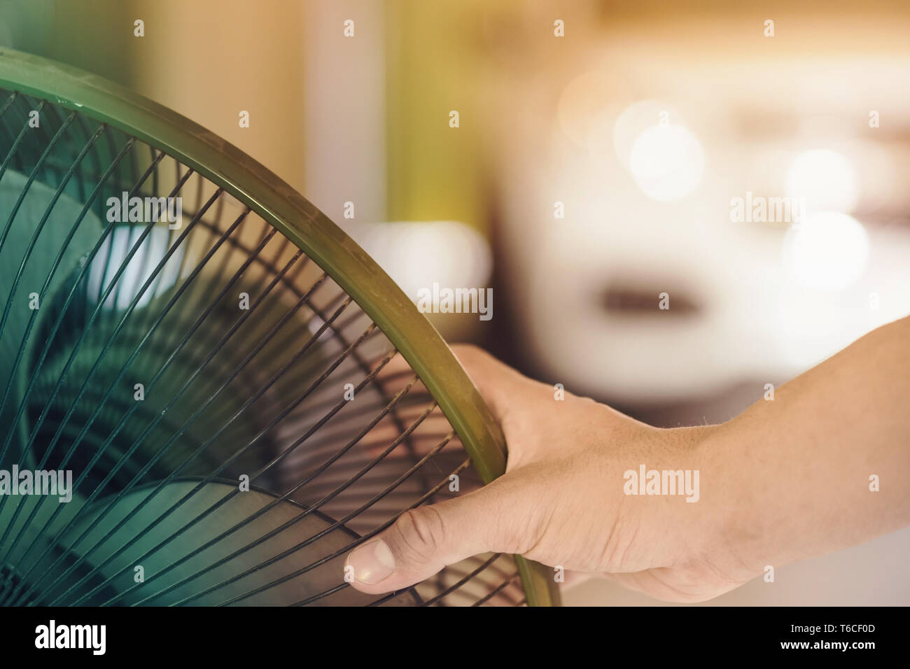 Hand of Young man touch and adjust on front grills of electric fan for ...