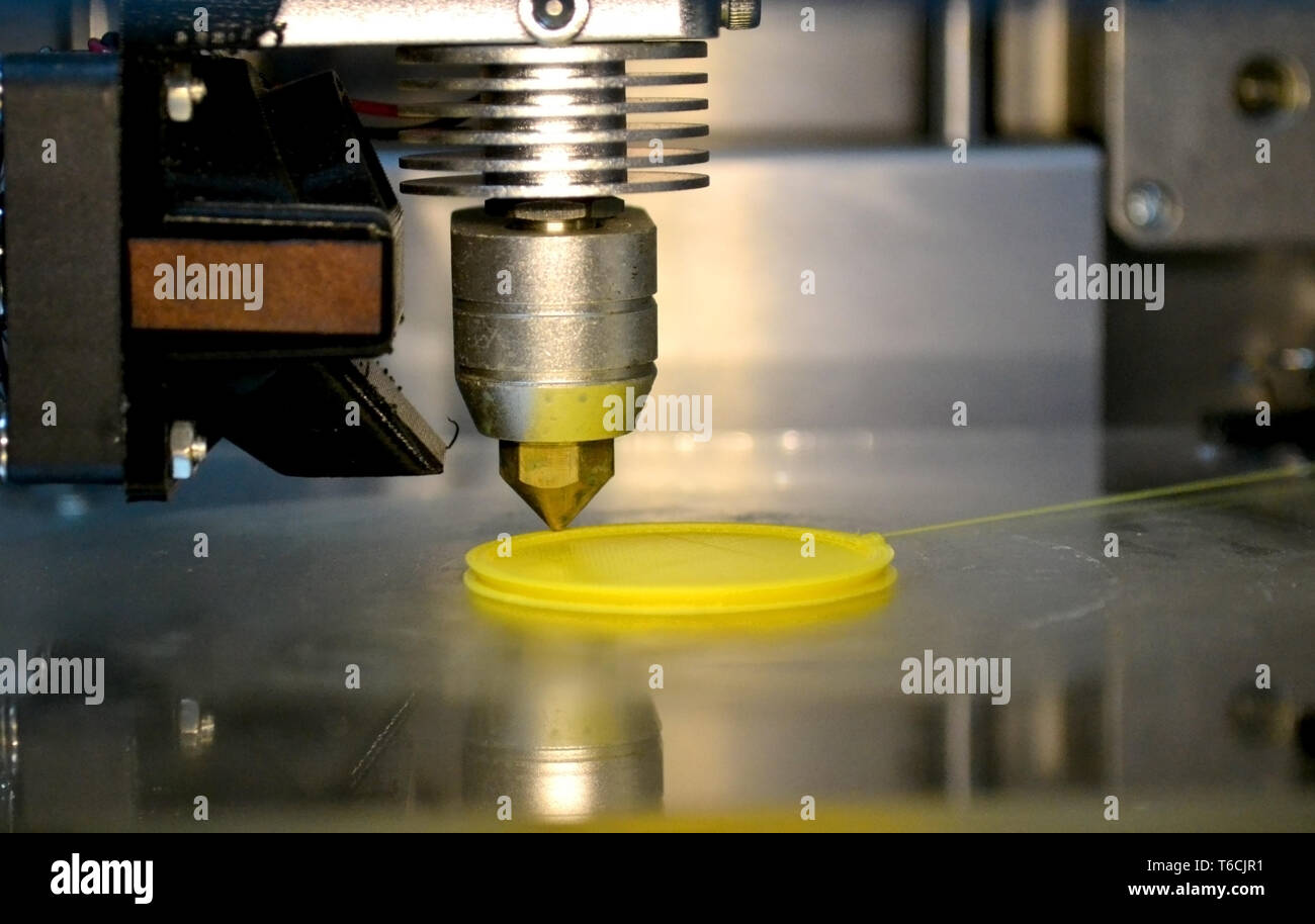 3D printer prints from the plastic figure closeup. 3D printer makes ...