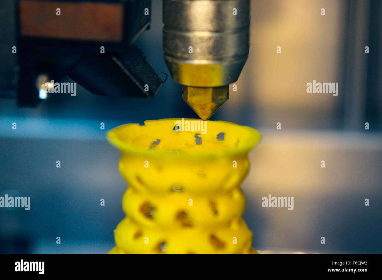 3D printer prints from the plastic figure closeup. 3D printer makes ...