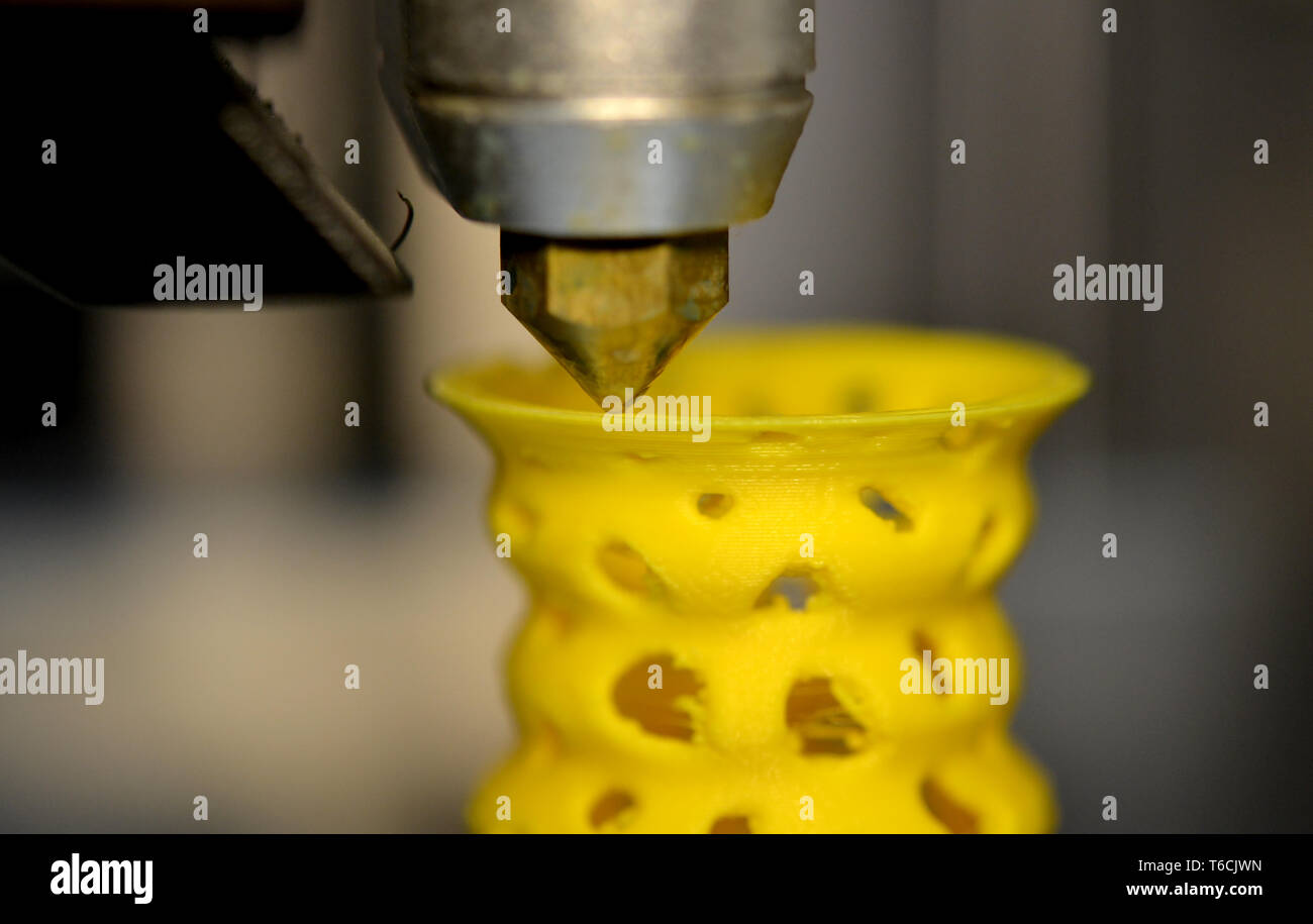 3D printer prints from the plastic figure closeup. 3D printer makes ...