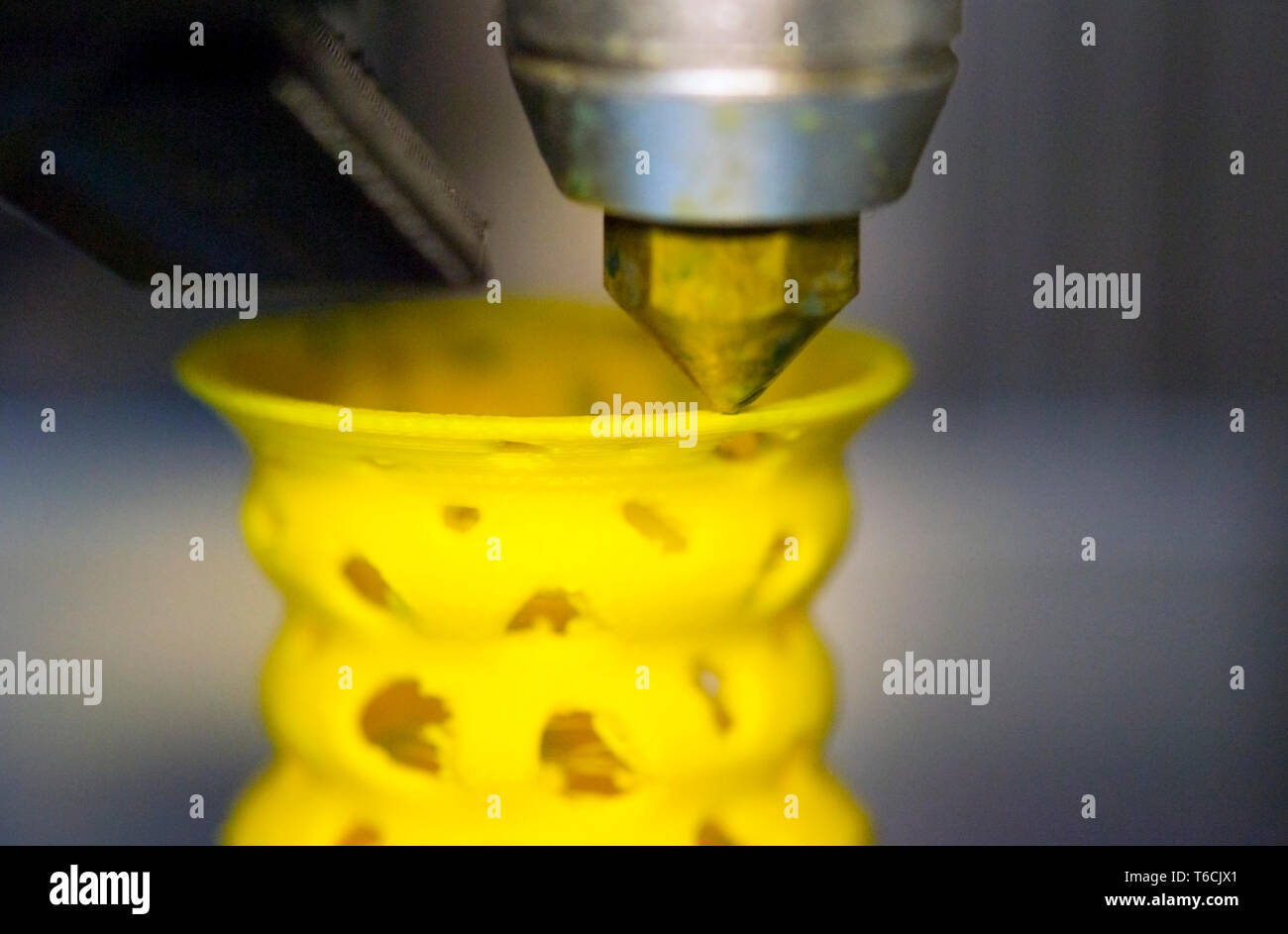 3D printer prints from the plastic figure closeup. 3D printer makes ...