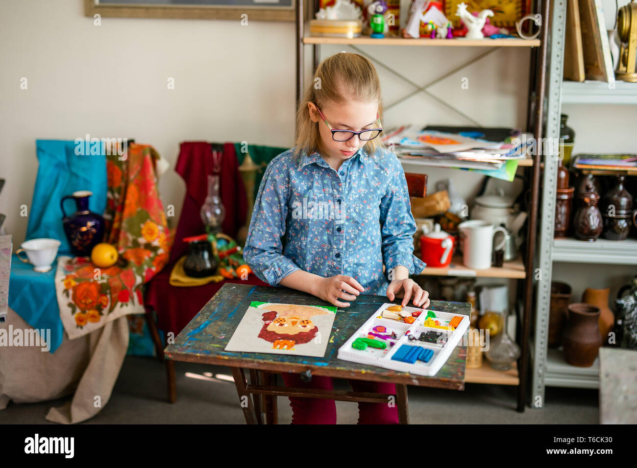 Smiling pretty blonde girl enjoying their time at art studio. close up ...