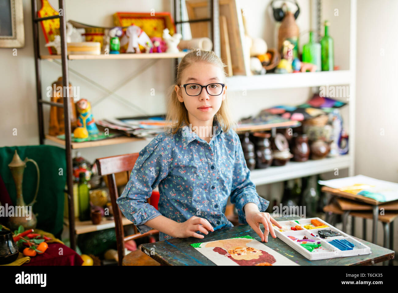Smiling pretty blonde girl enjoying their time at art studio. close up ...