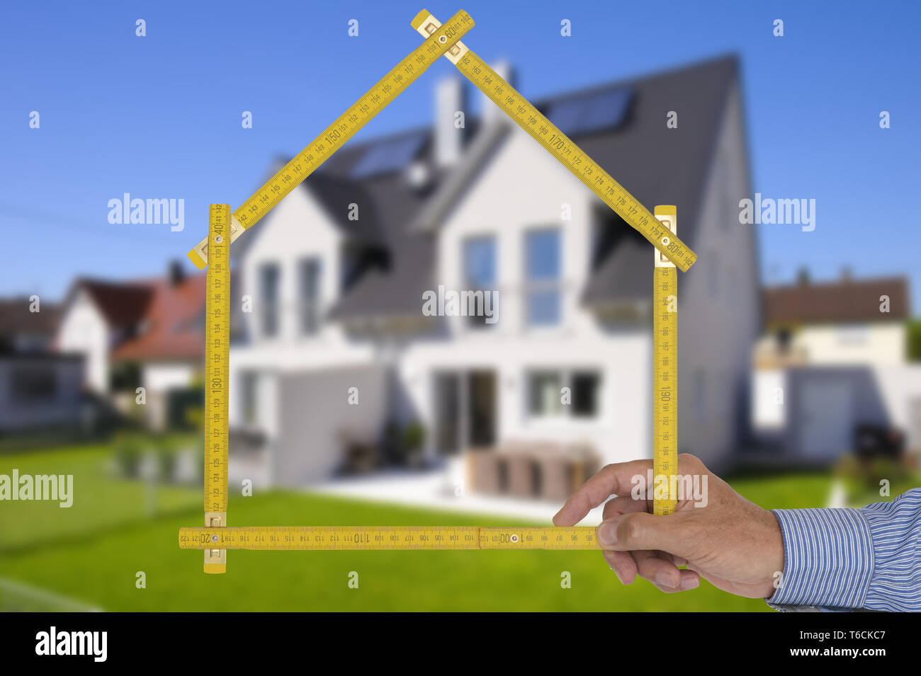 shell of house under construction with folding ruler in hand of real ...