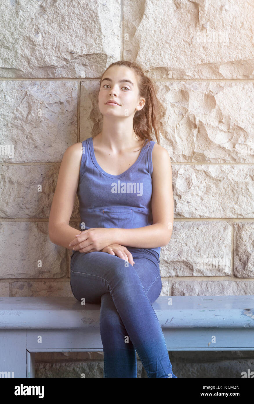 portrait of a smiling young woman sitting on a bench Stock Photo - Alamy