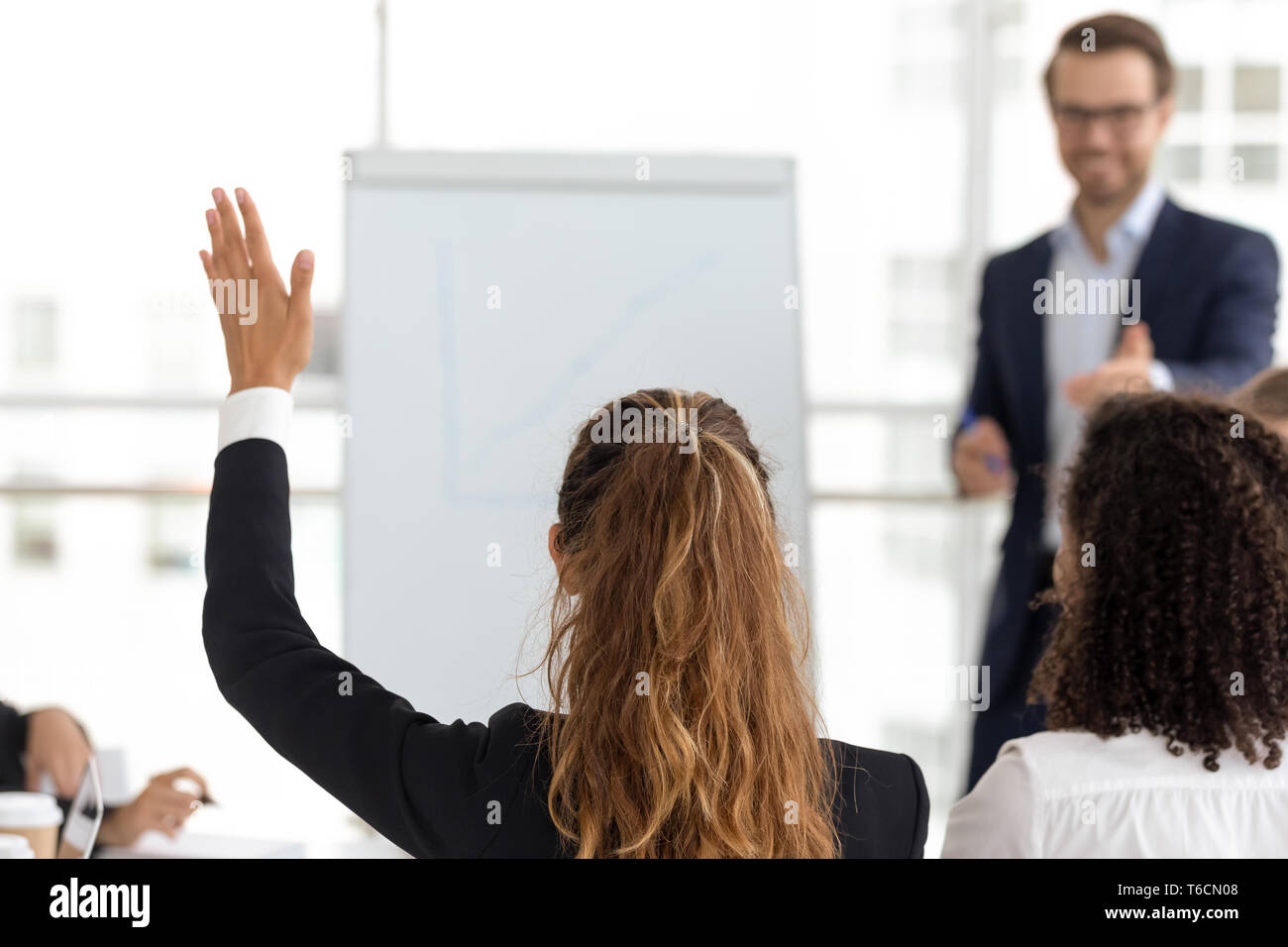 Training participant raise hand ask question at employees team workshop ...