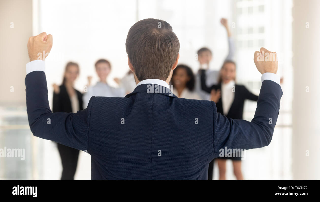Rear view at successful leader celebrating business victory with team ...