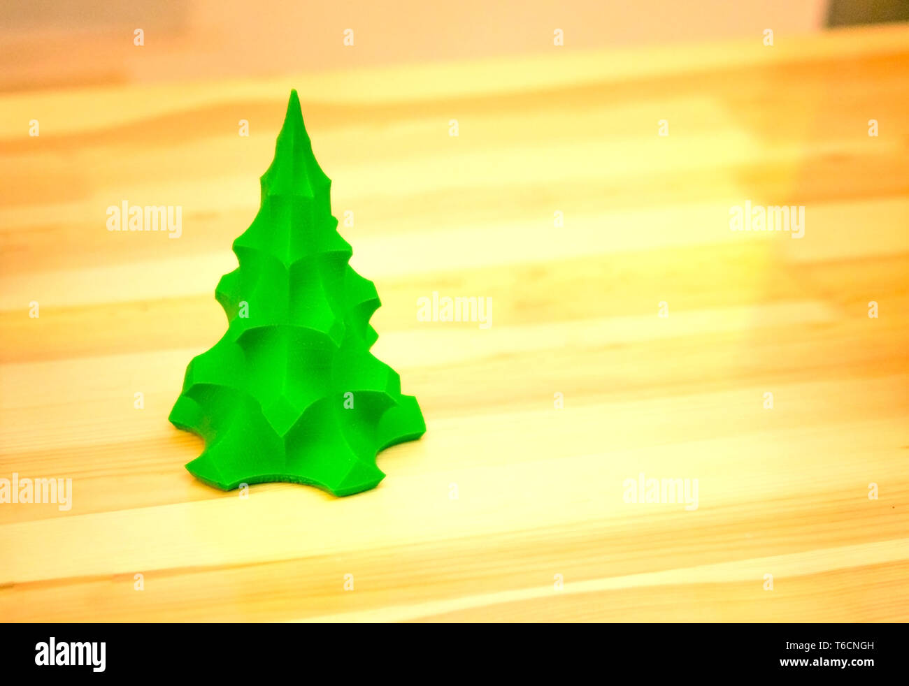 The model printed on a 3d printer. A small green tree is on the table ...