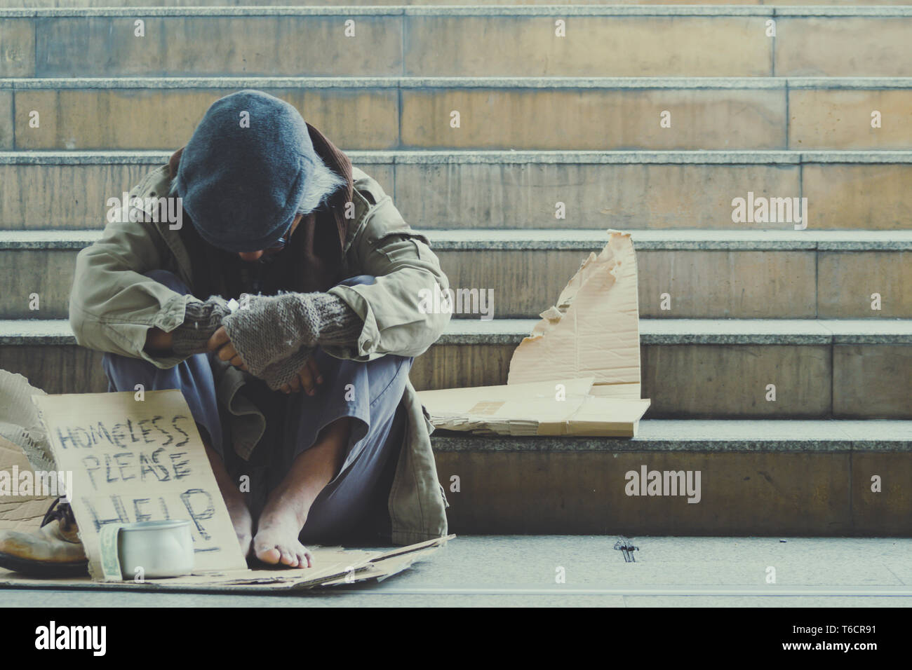 Homeless. Unhappy homeless man with black gloves is holding hand to get ...