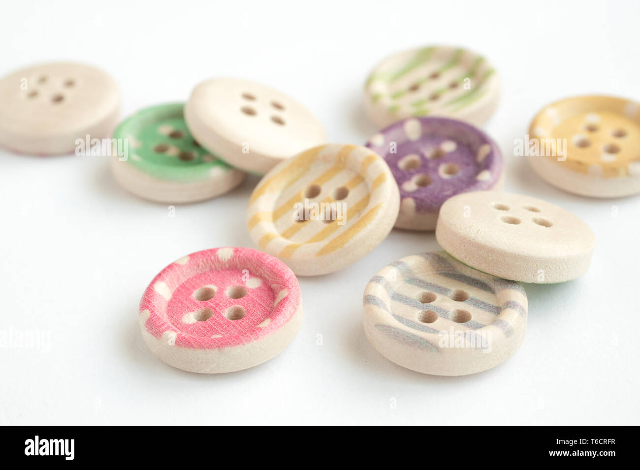 Wooden buttons with colorful stripes and colorful dots on a white ...