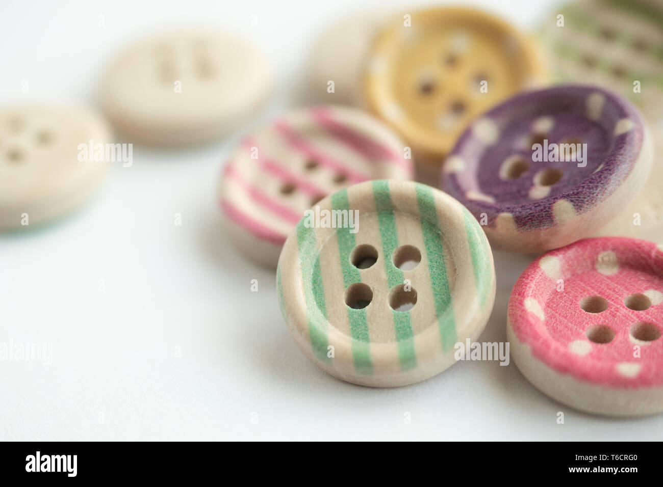 Wooden buttons with colorful stripes and colorful dots on a white ...