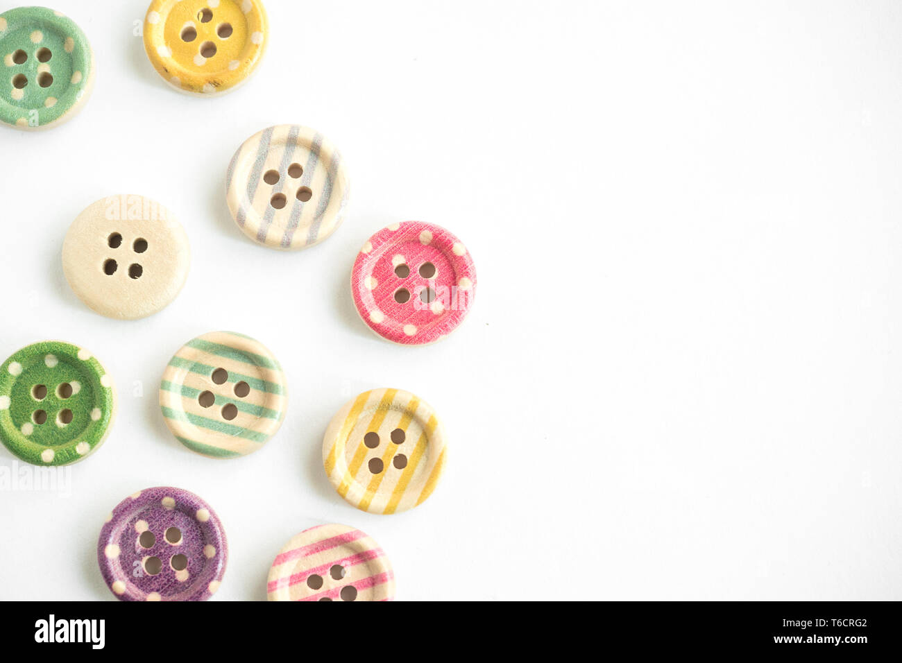 Wooden buttons with colorful stripes and colorful dots on a white ...