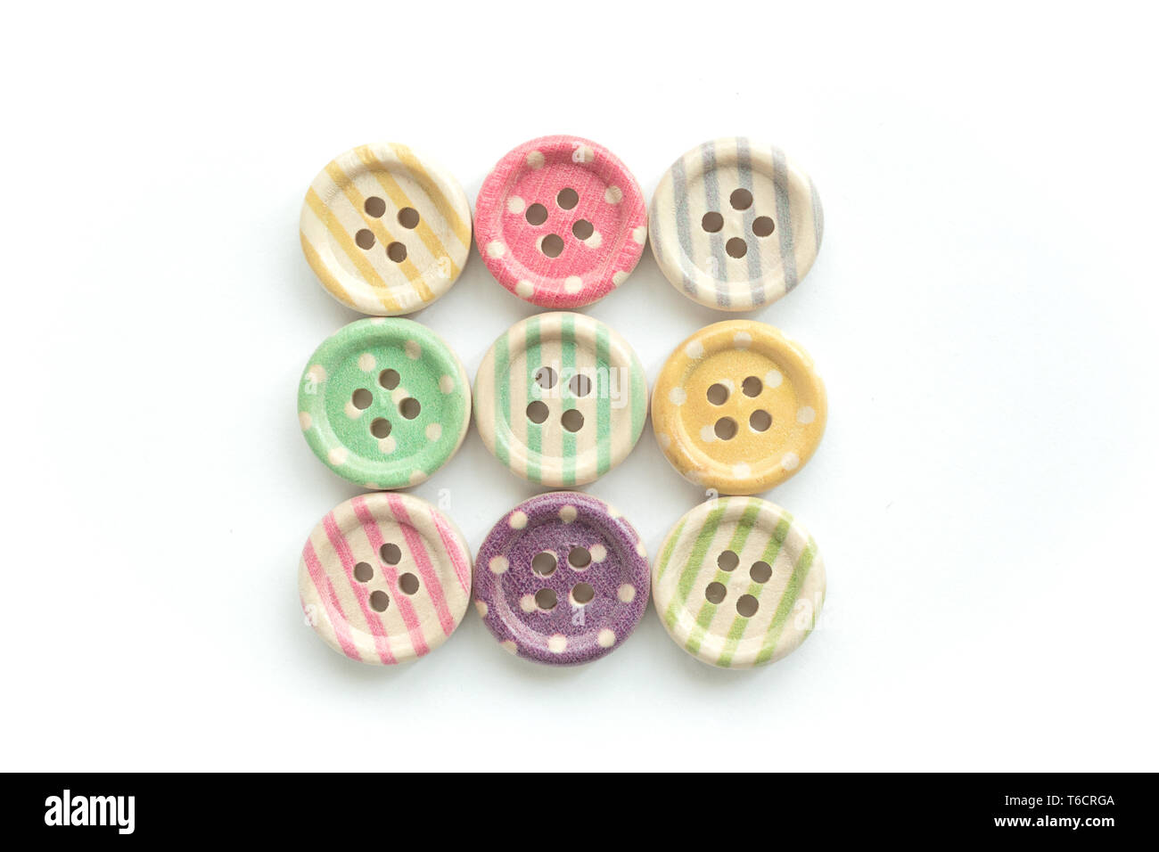 Wooden buttons with colorful stripes and colorful dots on a white ...
