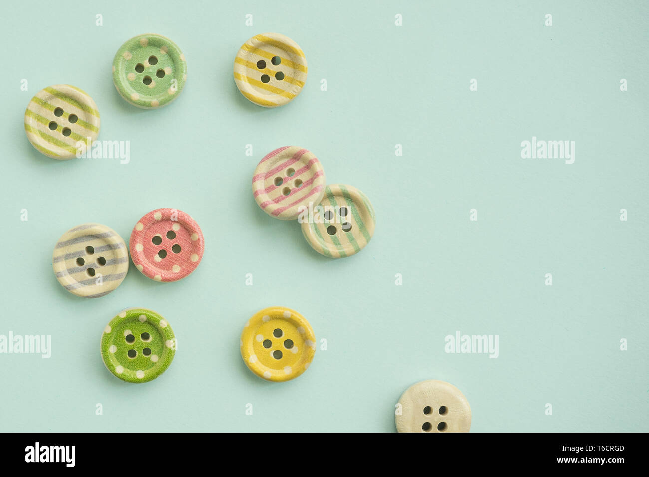 Wooden buttons with colored stripes and colorful dots on a pastel green ...