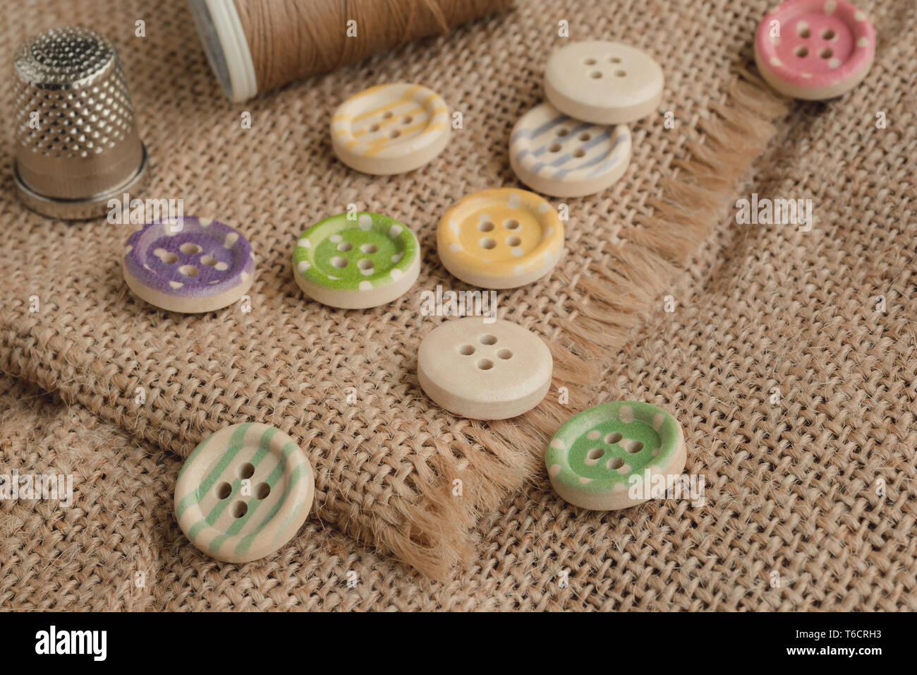 Wooden buttons with stripes of colored colors on a rustic fabric ...