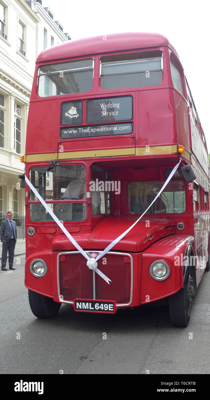 A red Routemaster bus on a London street with ribbon wedding ...
