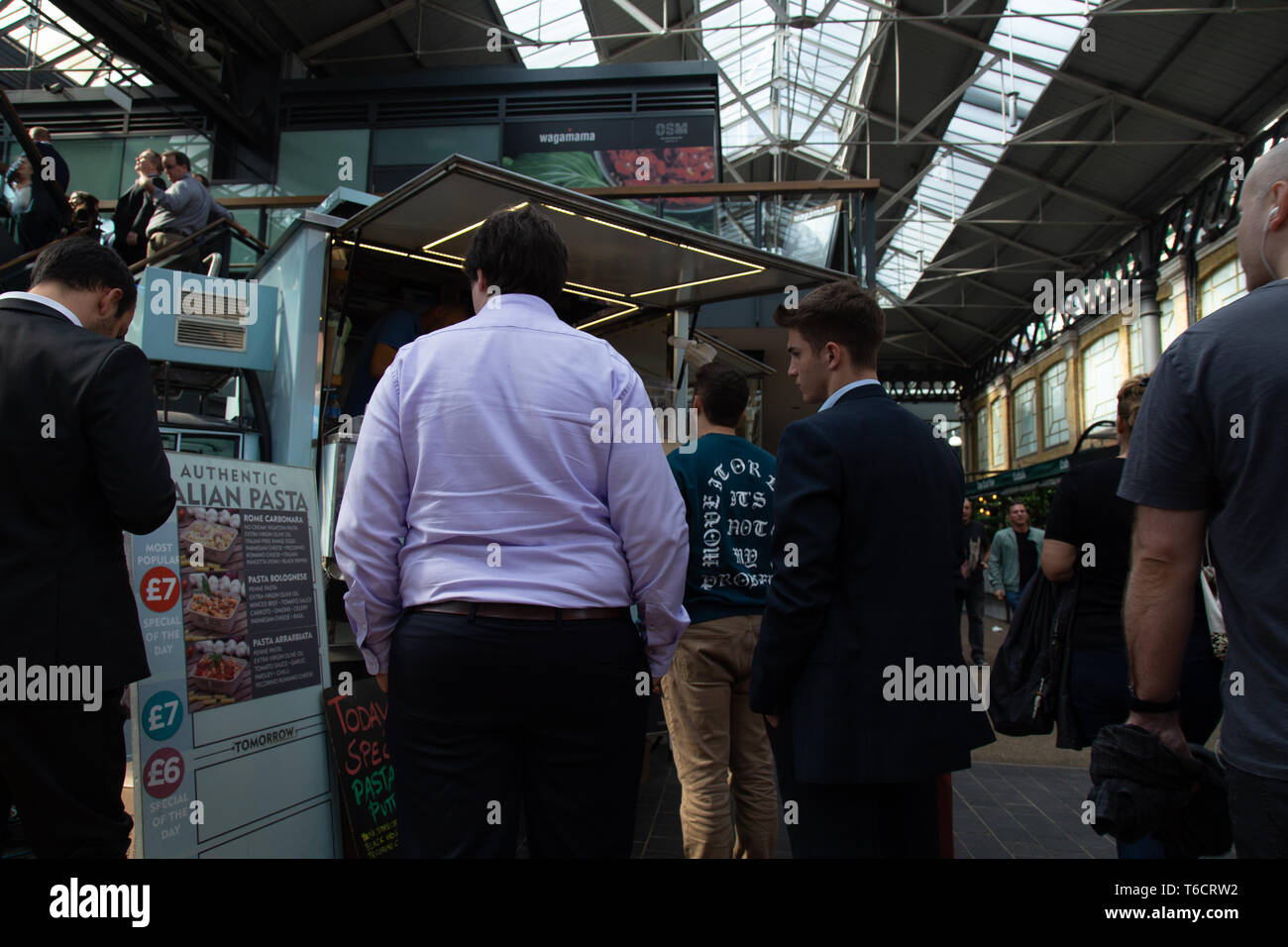 Two businessmen in line at the Italian street food inside of the Old ...