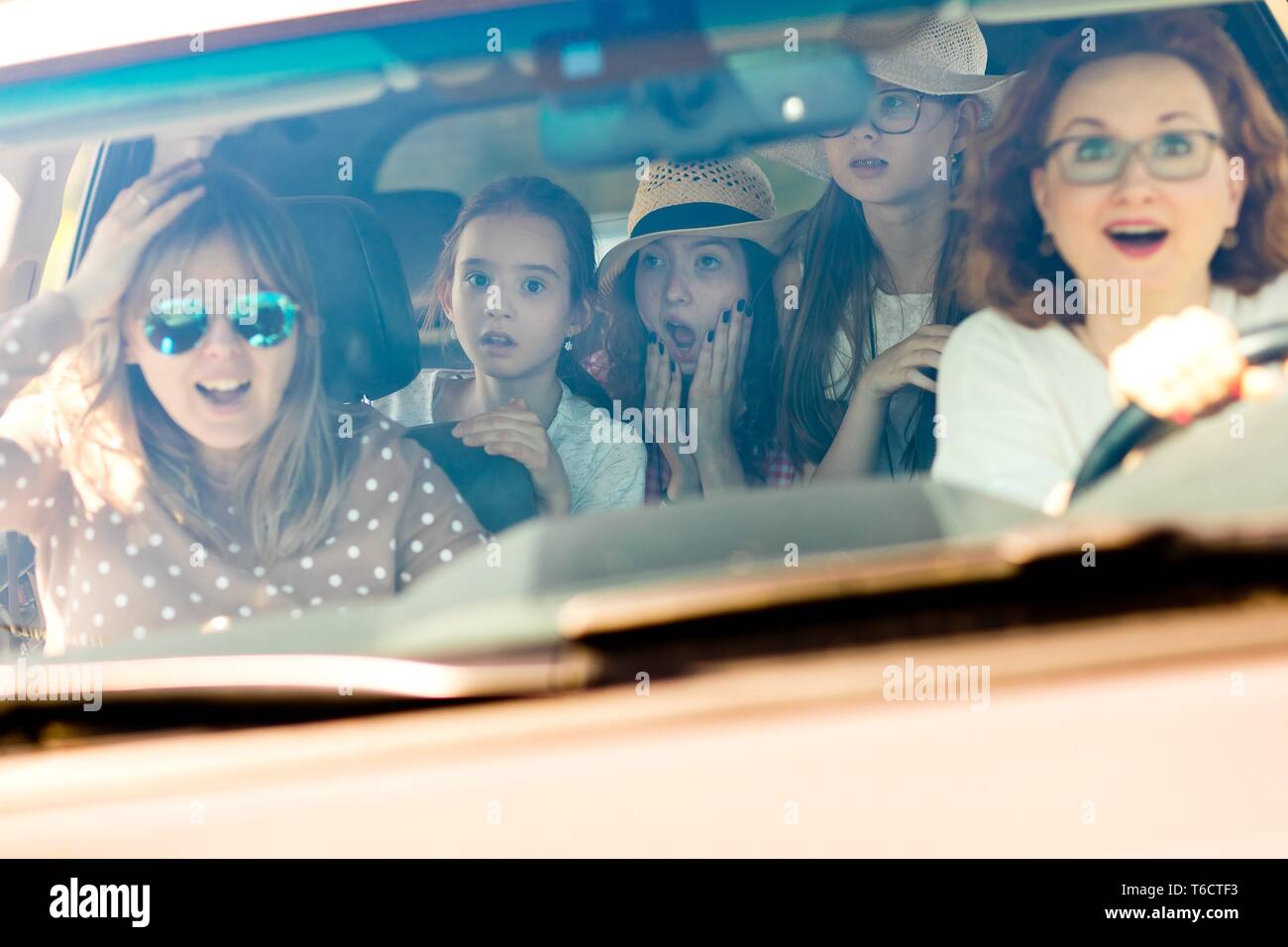 Two mothers with three daughters scared in car - looking amazed by ...
