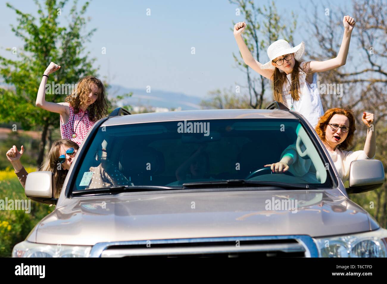 Rioters behind the wheel, female hooligans in the car showing gestures ...