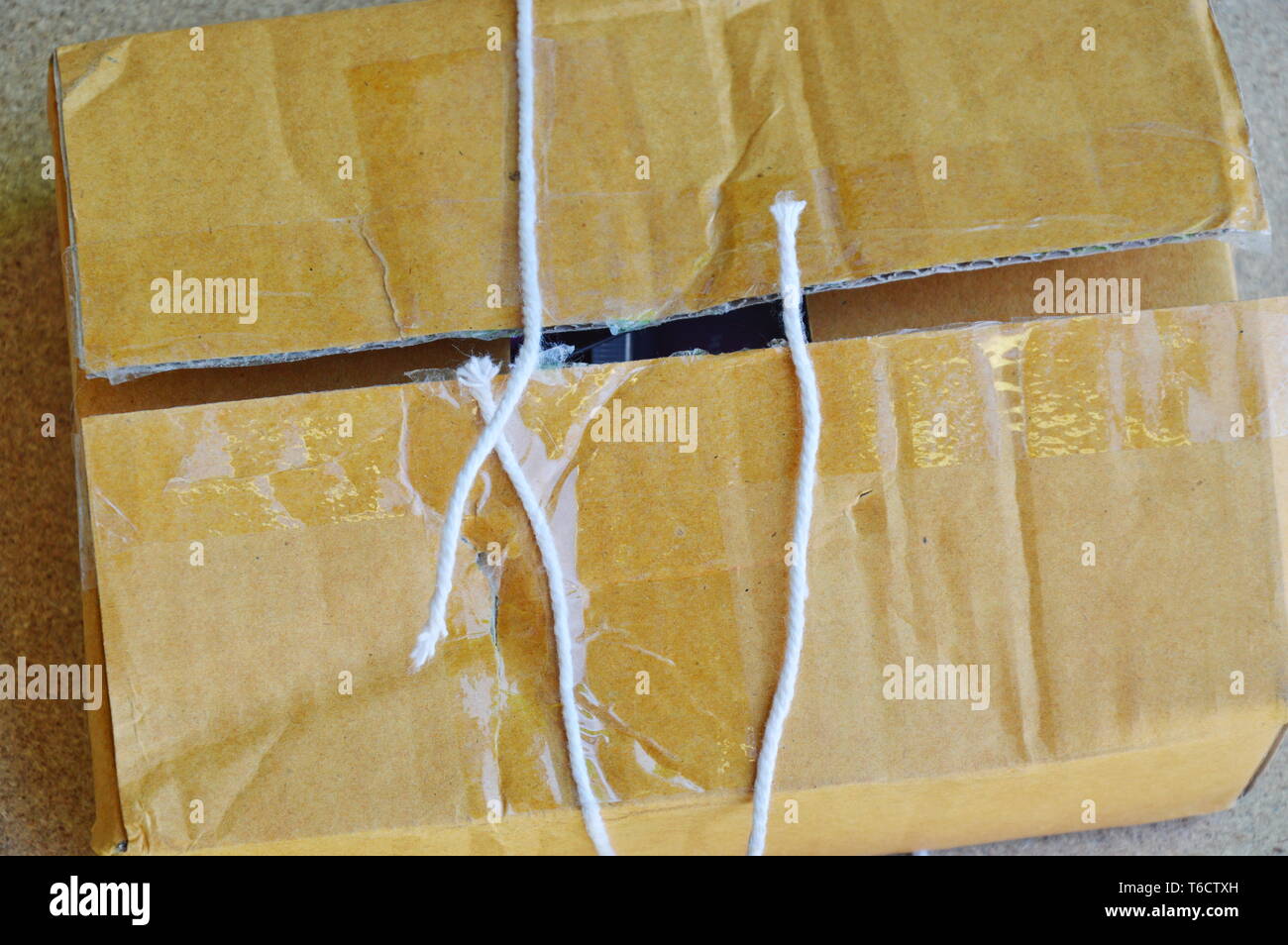 parcel rope cut and open brown postal box Stock Photo - Alamy