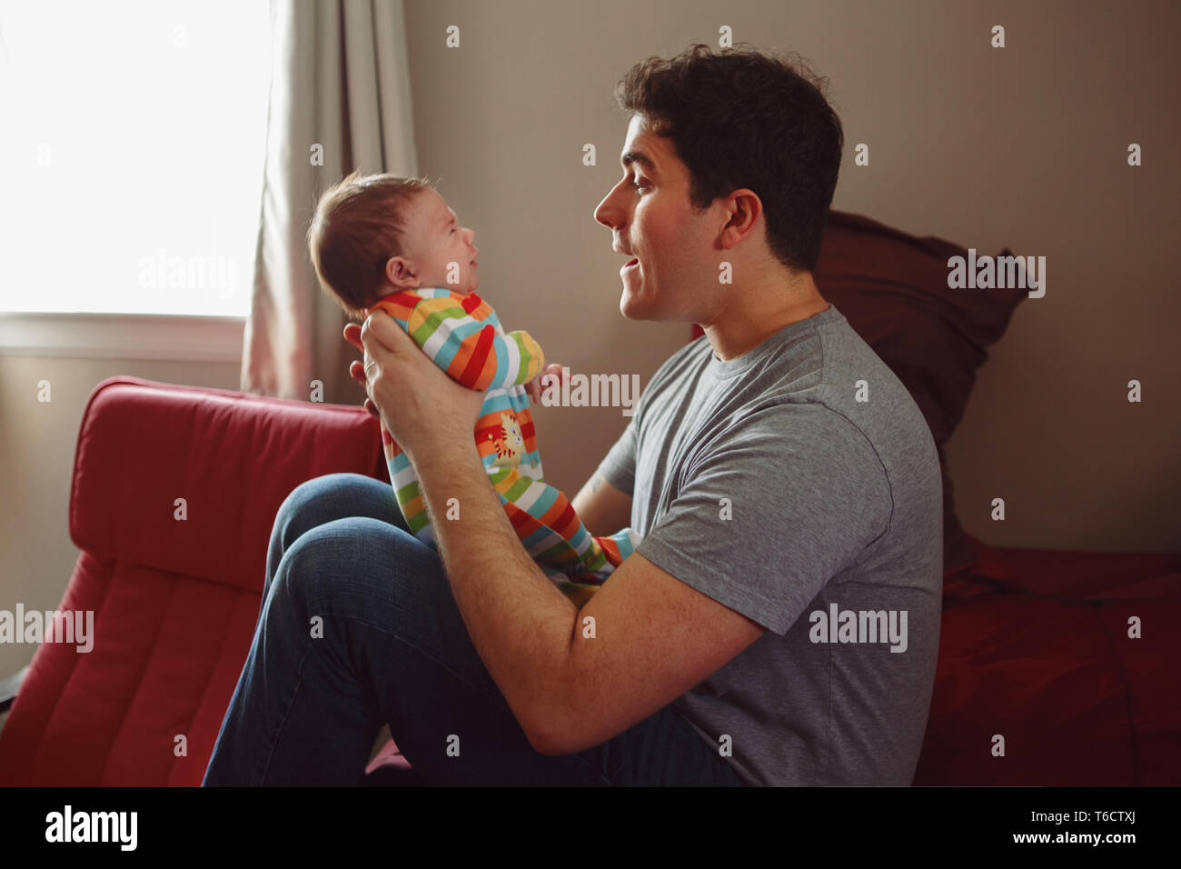 Young Caucasian father trying to calm down crying newborn baby. Male ...