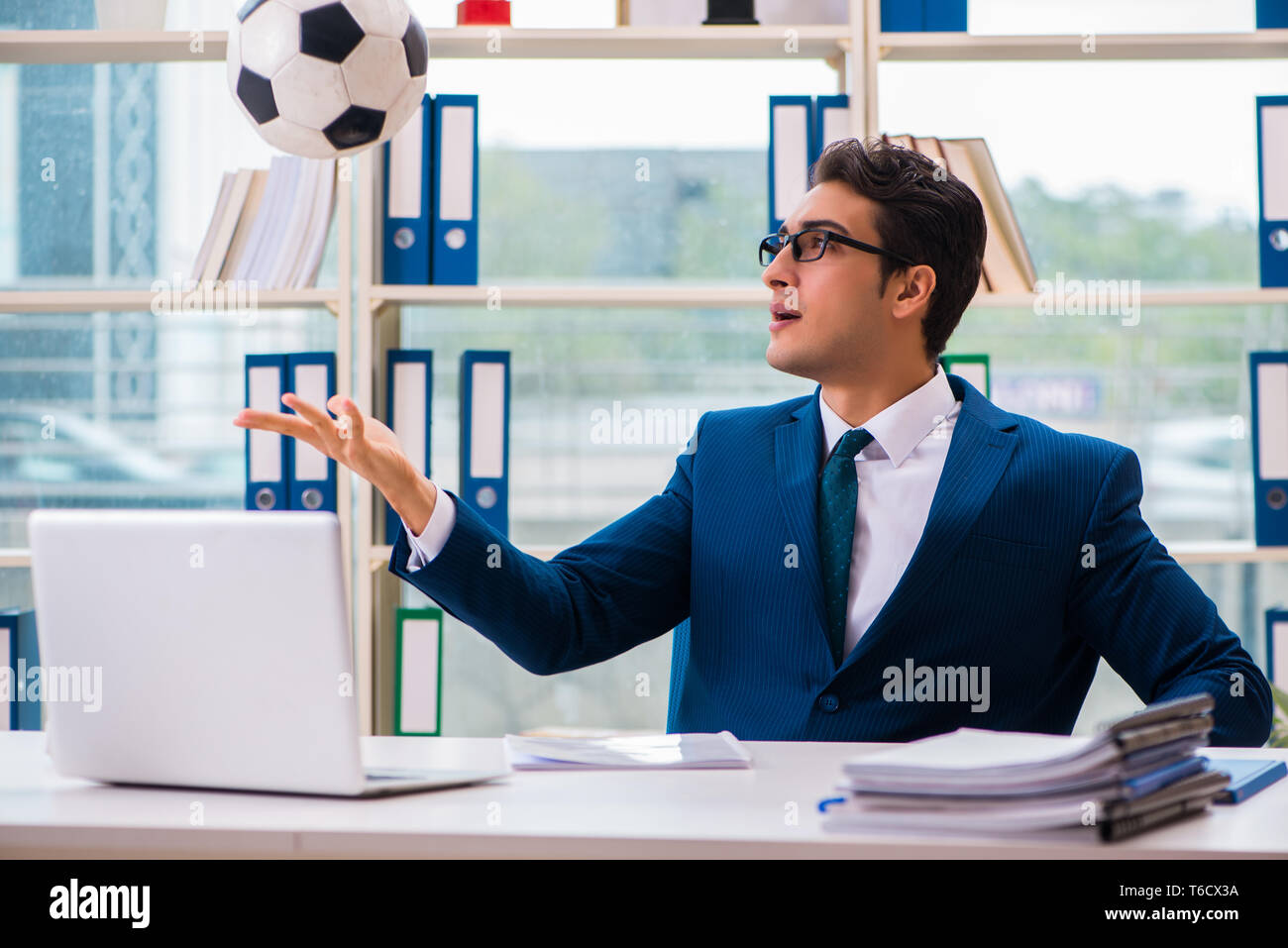 Businessman playing football in the office Stock Photo - Alamy