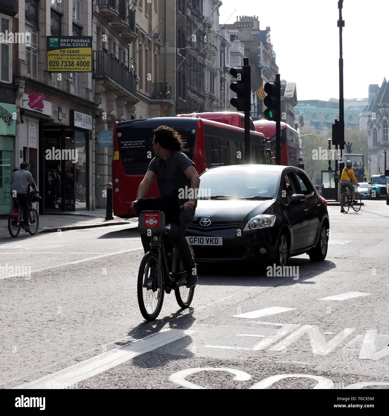 Cyclist looks over shoulder as car approaches, London, England, UK ...