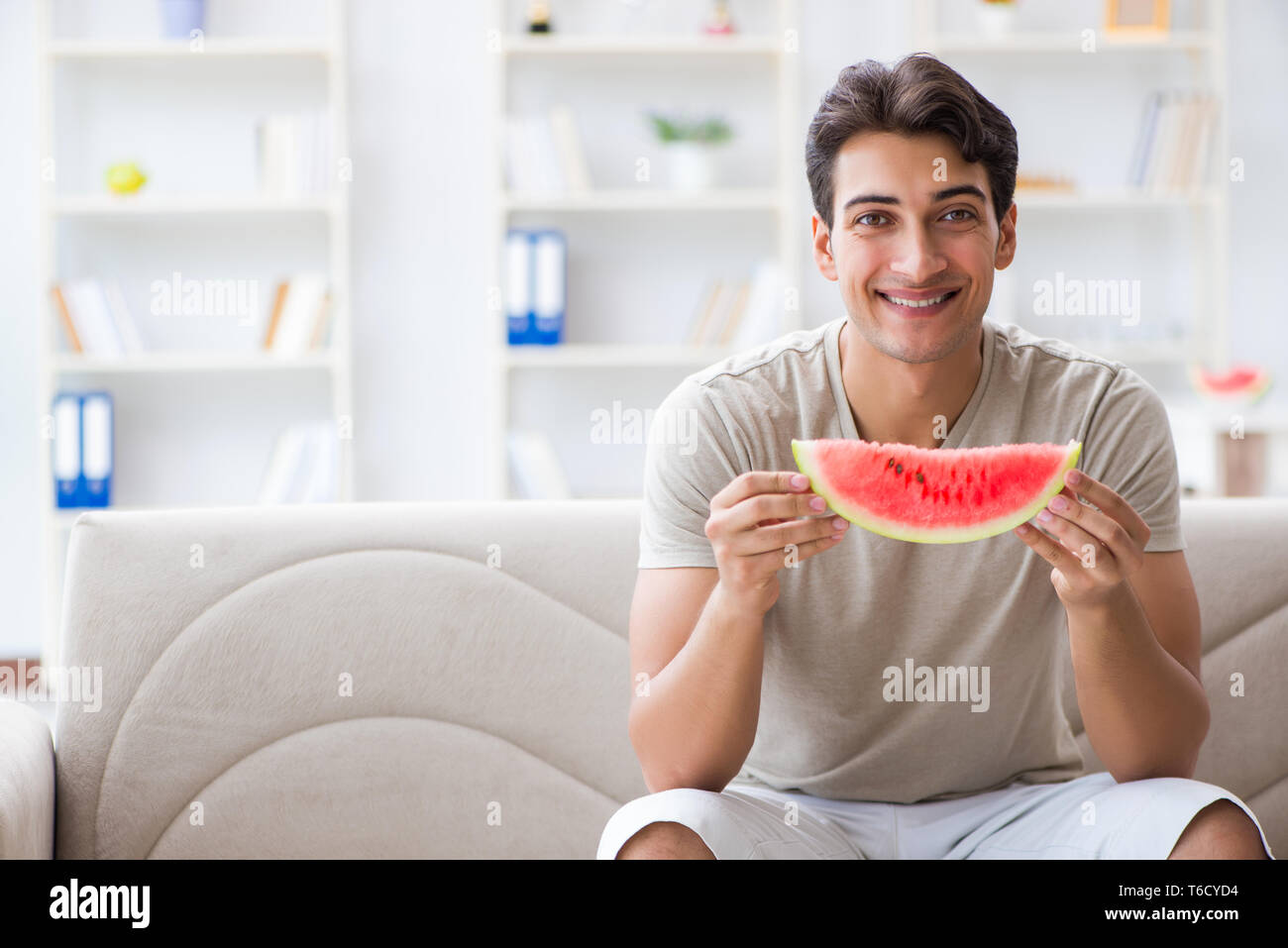 Man eating watermelon at home Stock Photo - Alamy
