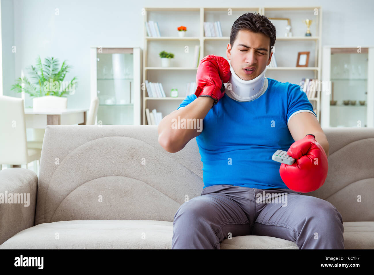 Man with neck injury watching boxing at home Stock Photo - Alamy