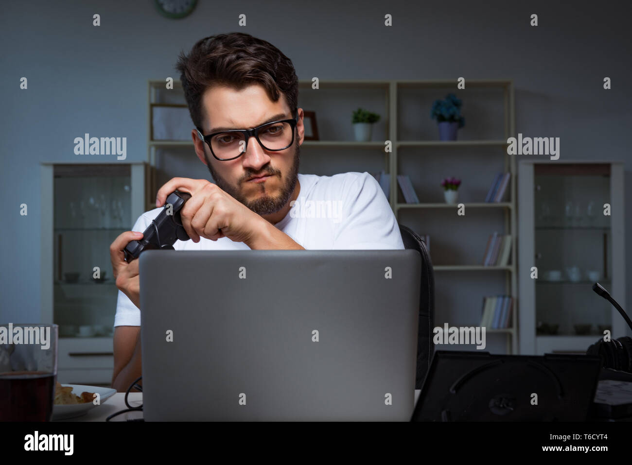Young man playing games long hours late in the office Stock Photo - Alamy