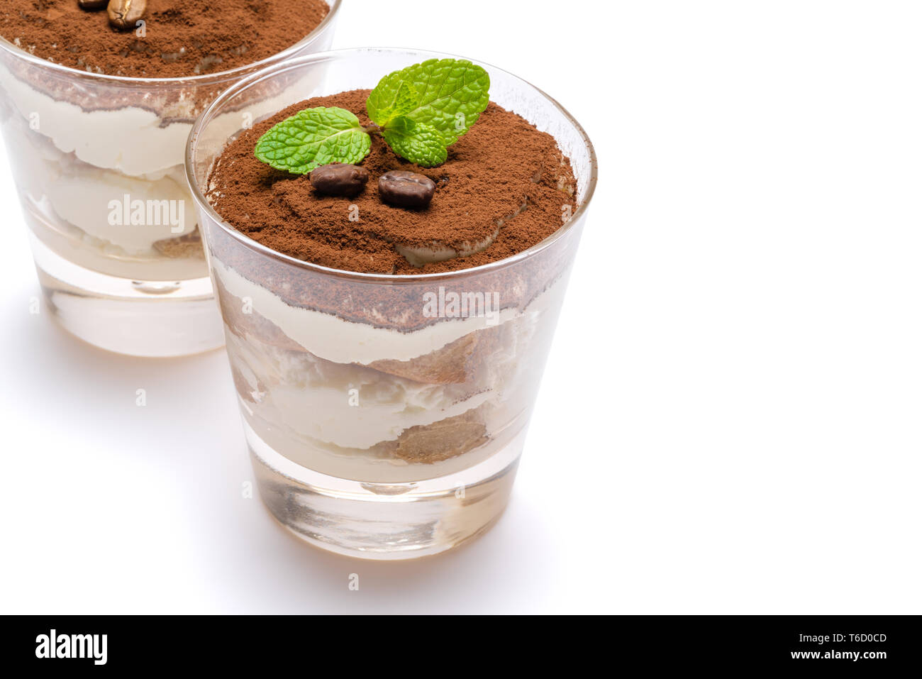 two portions Classic tiramisu dessert in a glass isolated on a white ...