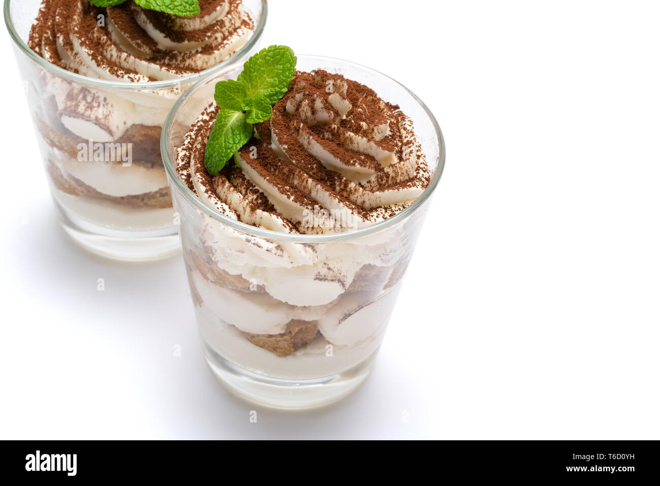 two portions Classic tiramisu dessert in a glass isolated on a white ...