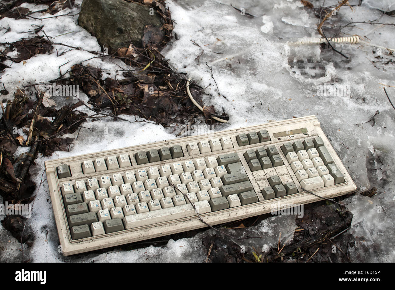 Abandoned dirty broken grunge computer keyboard on snowy frozen soil ...