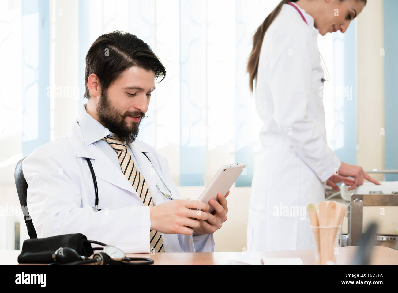 Doctor and his assistant in clinic Stock Photo - Alamy