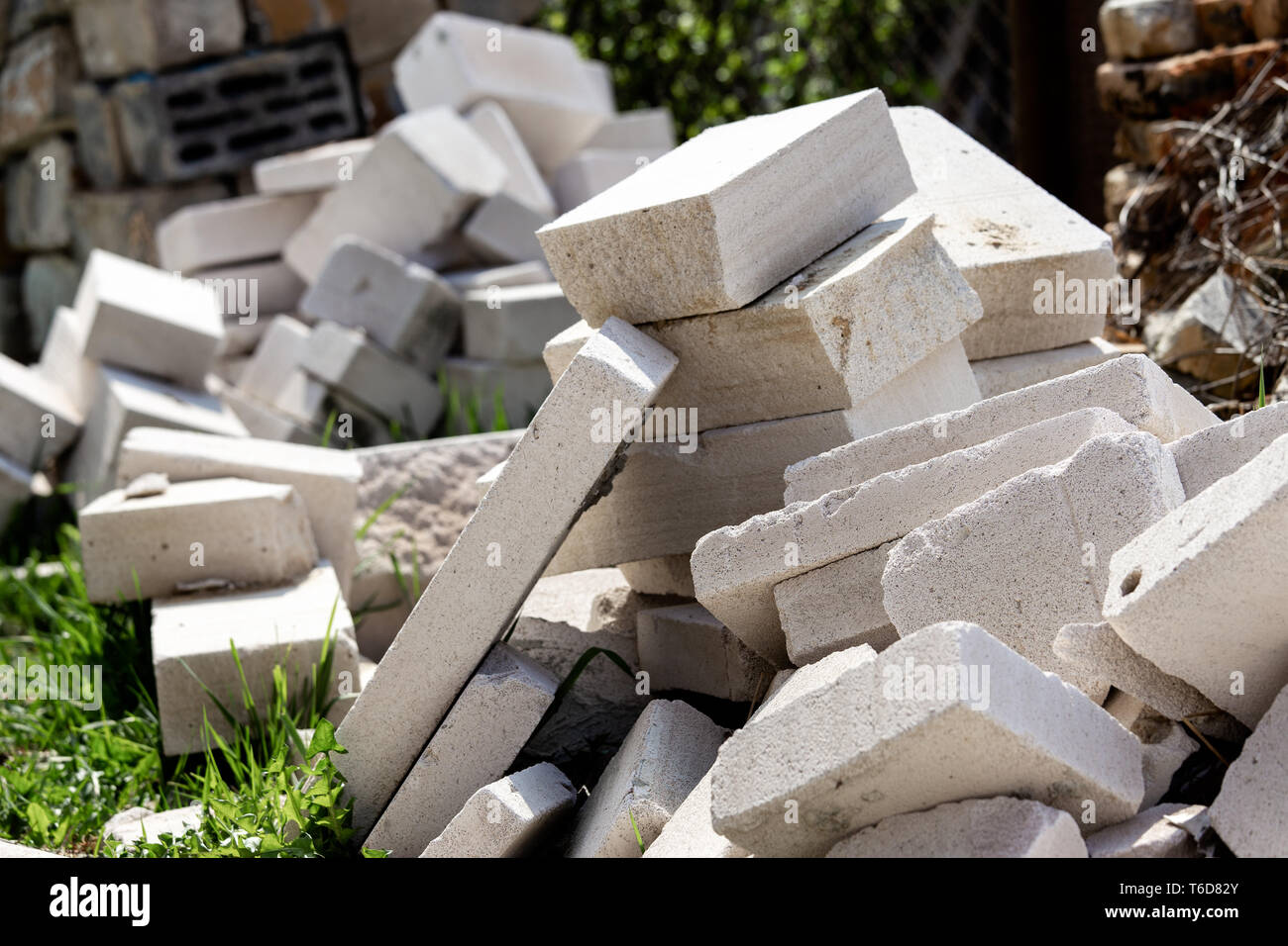 A pile of construction waste is in the yard. White brick or foam block ...