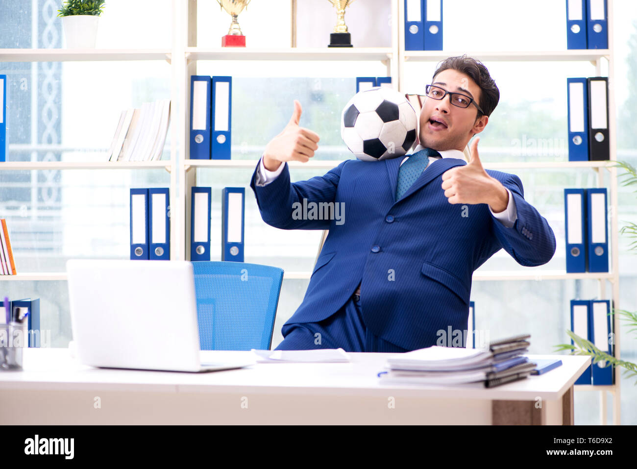 Businessman playing football in office hi-res stock photography and ...