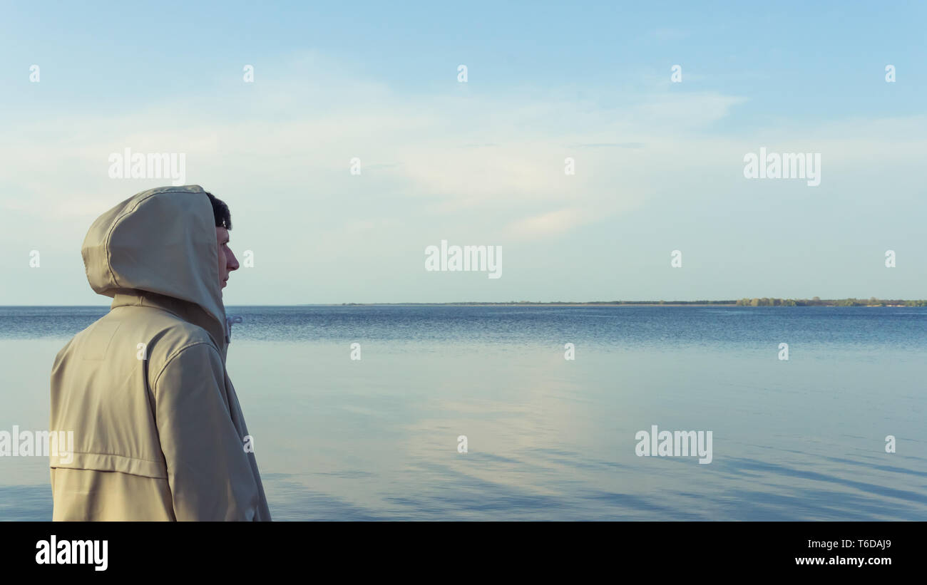 The pensive man standing near the sea. The man looking at the horizon ...