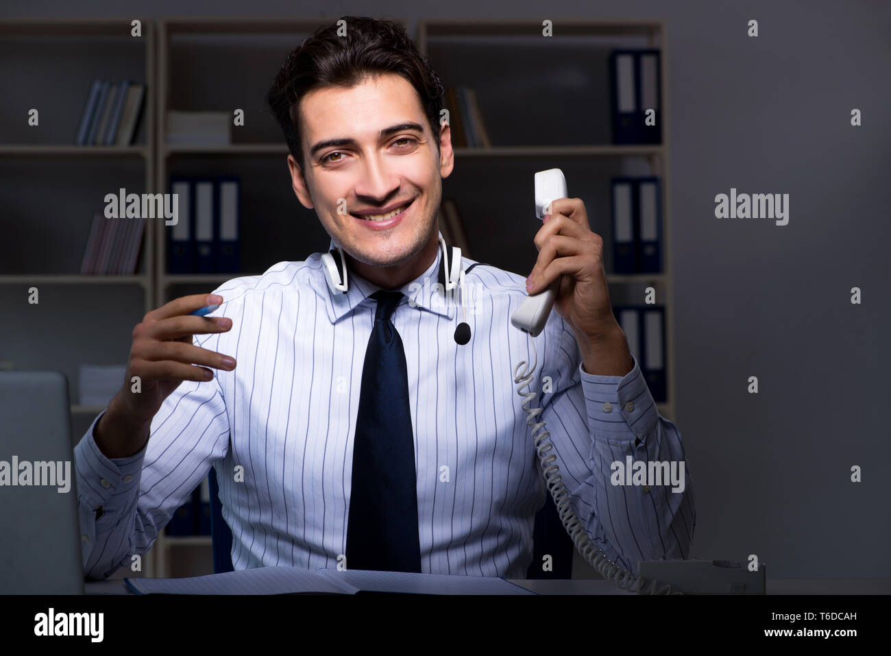 Call center operator talking to customer during night shift Stock Photo ...