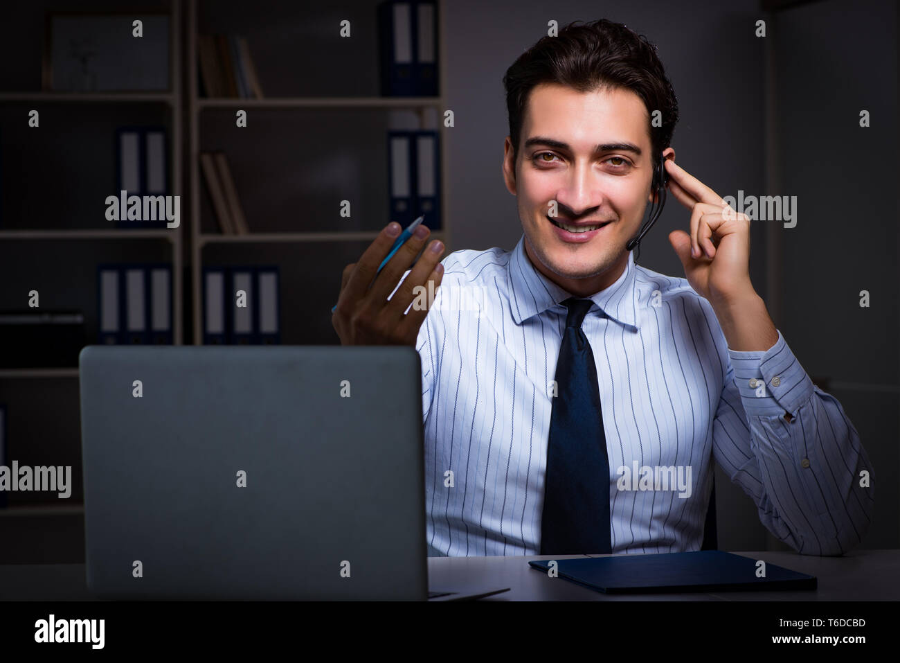 Call center operator talking to customer during night shift Stock Photo ...