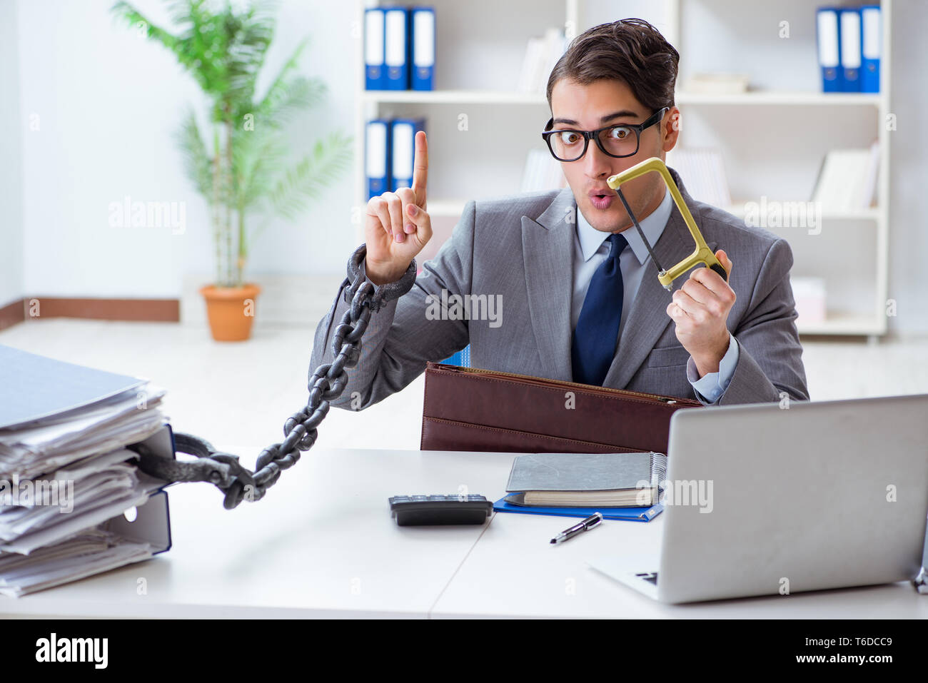 Busy employee chained to his office desk Stock Photo - Alamy
