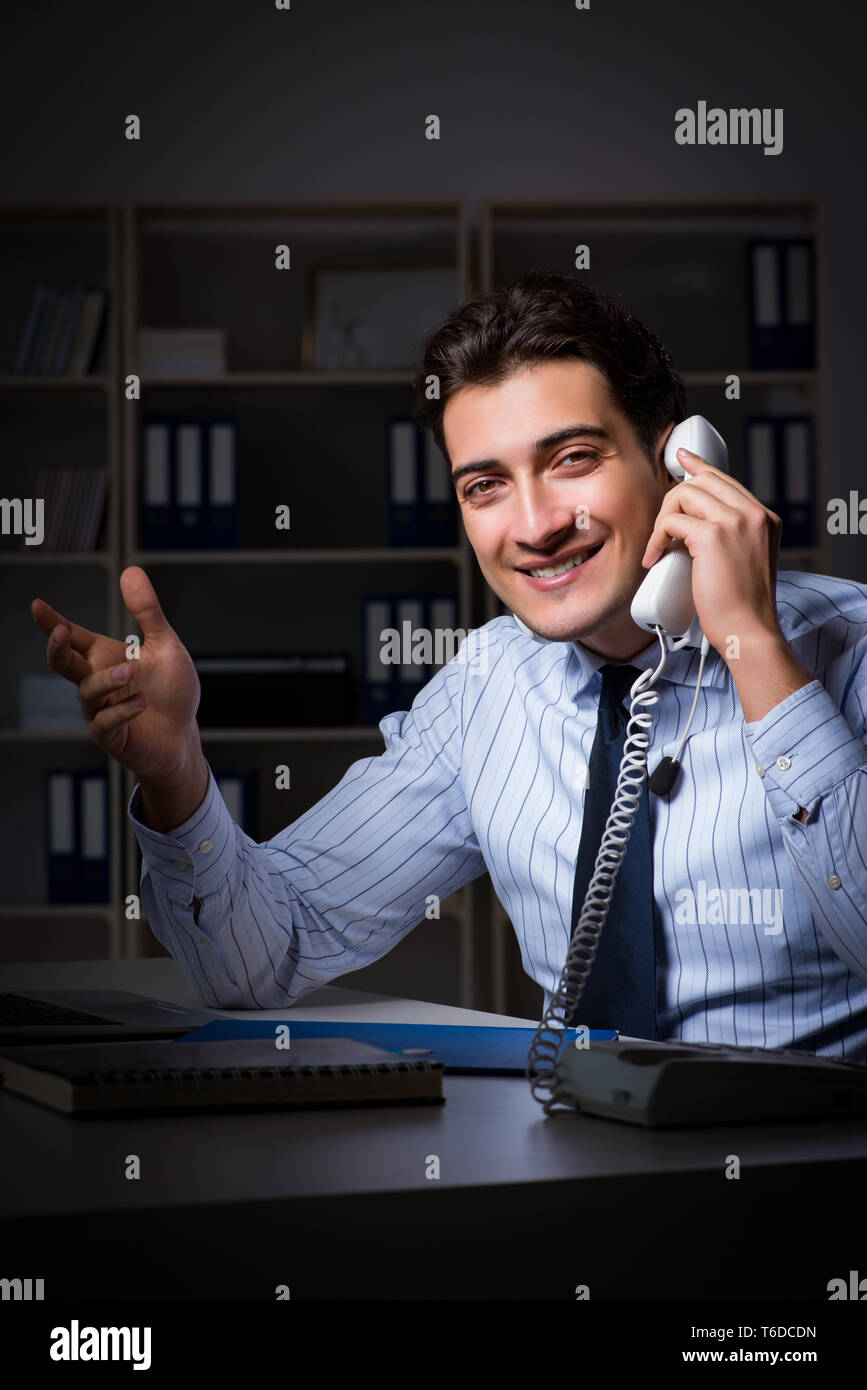 Call center operator talking to customer during night shift Stock Photo ...